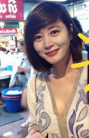 A Woman Is Holding Up Two Bananas In Front Of Her Face And Smiling At