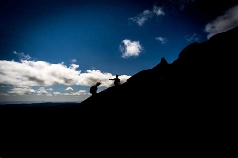 Premium Photo Silhouette Of Two People Climbing Mountain