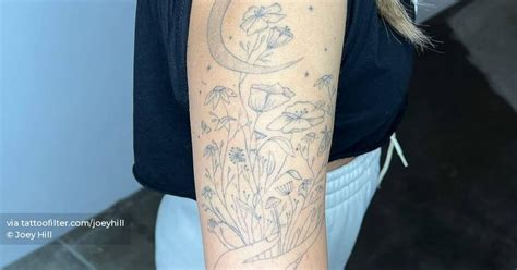 Fine Line Hand Holding Flowers Tattoo On The Upper Arm