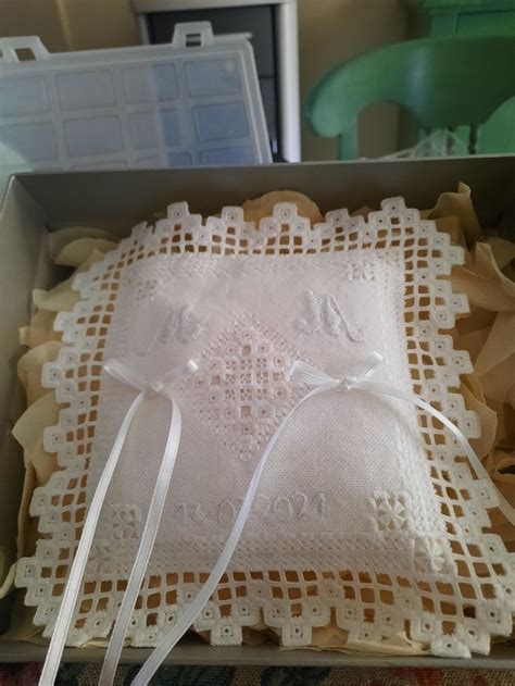 A Box That Has Some White Doily In It With A Bow On The Side