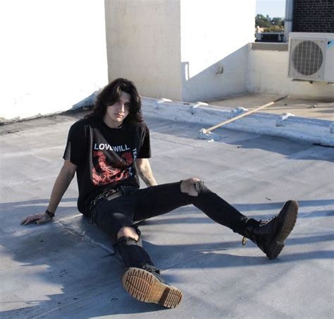 A Man With Long Hair Sitting On The Ground