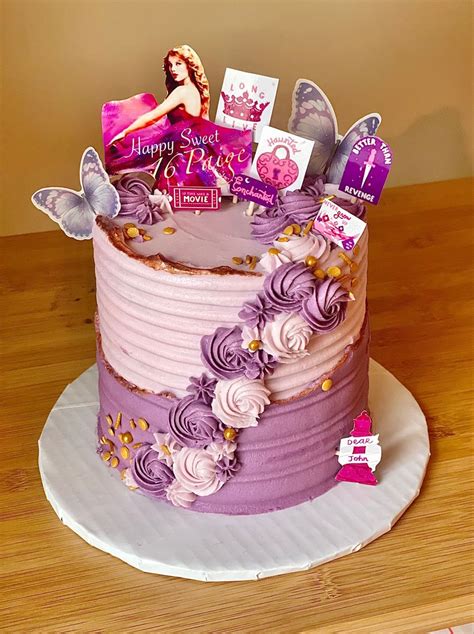 A Birthday Cake With Purple Frosting And Cards On Top Sitting On A
