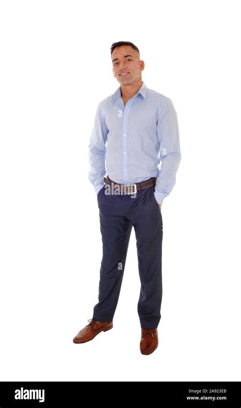 A Handsome East Indian Man Standing In Dress Pants And A Blue Shirt