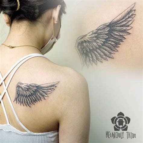 The Back Of A Woman S Shoulder With Black Angel Wings On Her Upper Arm
