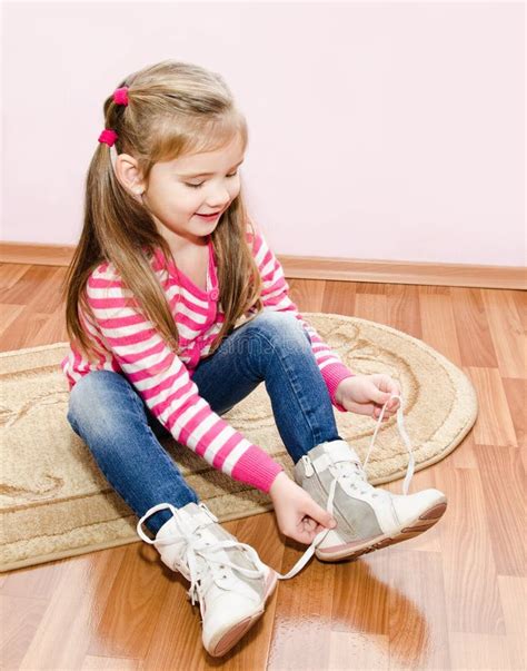 Petite Fille Mignonne Attachant Ses Chaussures De Blanc Image Stock