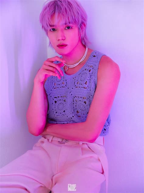 A Woman With Pink Hair Is Sitting On The Floor And Holding Her Hand Up
