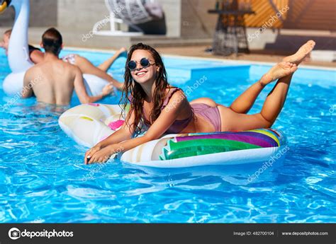 Joven chica caliente en bikini divirtiéndose y riendo en colchón