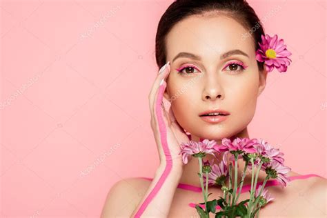 hermosa mujer desnuda con líneas de color rosa en el cuerpo y la flor