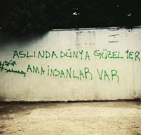 Graffiti Written On The Side Of A Wall In An Urban Area With Trees