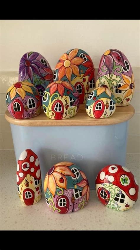 Several Colorfully Painted Rocks Sitting On Top Of A Blue Container
