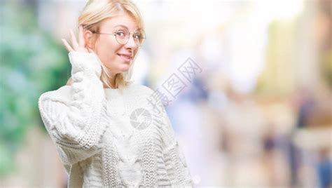 美丽的年轻金发女郎穿着冬季毛衣在孤立的背景下微笑着用手捂着耳朵听谣言或八卦高清图片下载 正版图片505802753 摄图网