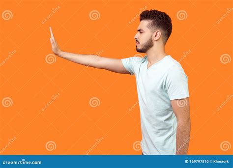 Stop Side View Of Serious Bossy Brunette Man Holding Out Hand To Left