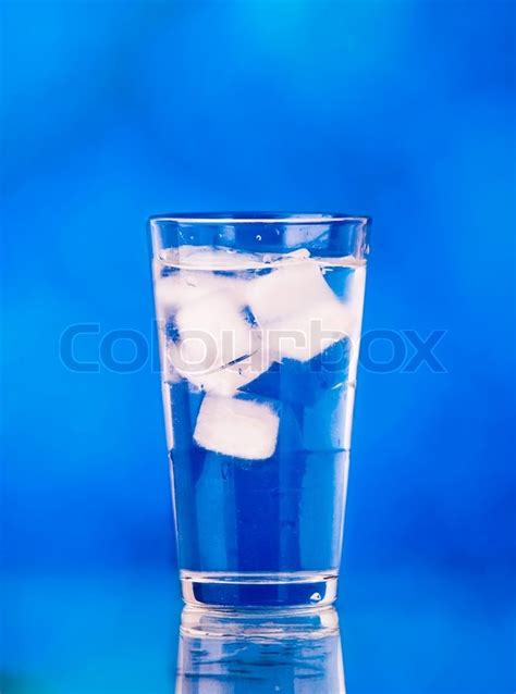 Glas vand på blå baggrund vand med is Stock foto Colourbox