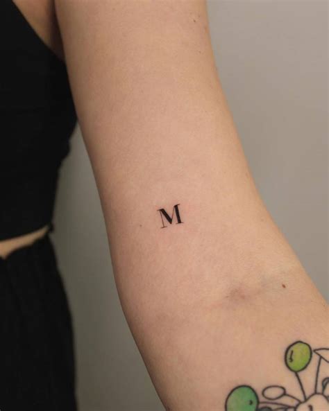 Tattoo Of The Letter M Located On The Bicep