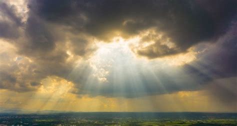 O raio de sol brilha através das nuvens nubladas Foto Premium