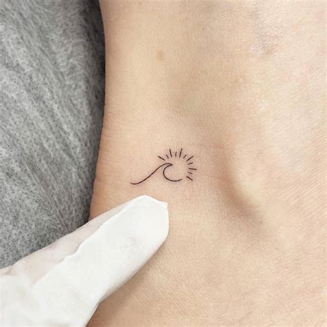 Minimalistic Style Sun And Wave Tattoo Located On The
