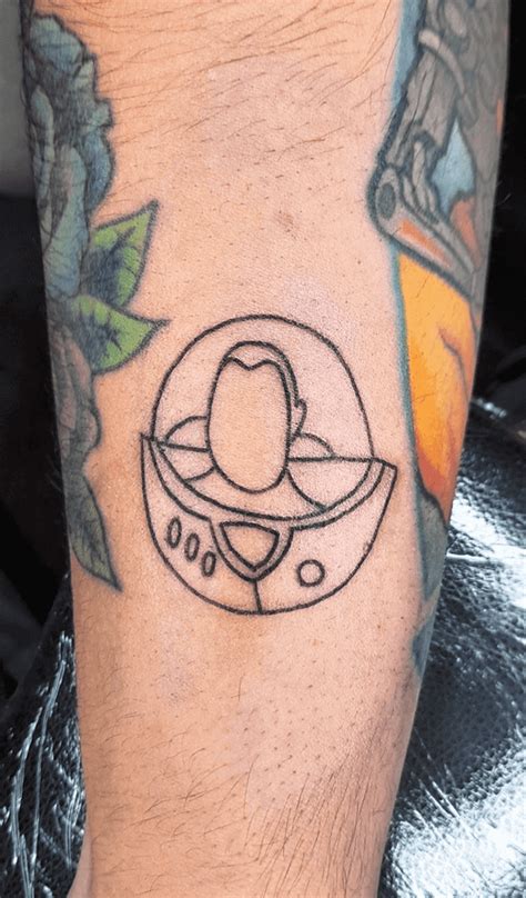 A Man With A Tattoo On His Leg That Has An Image Of A Spaceship In It