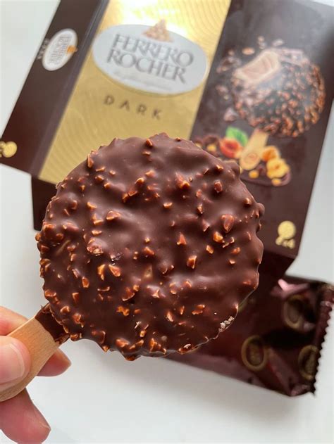 A Hand Holding A Chocolate Covered Donut With Sprinkles