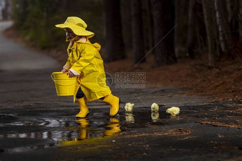 一个小孩在雨中玩耍而小妞高清图片下载 正版图片505871898 摄图网