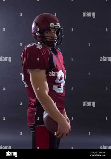 Portrait Of A Strong Muscular American Football Player Isolated On Gray