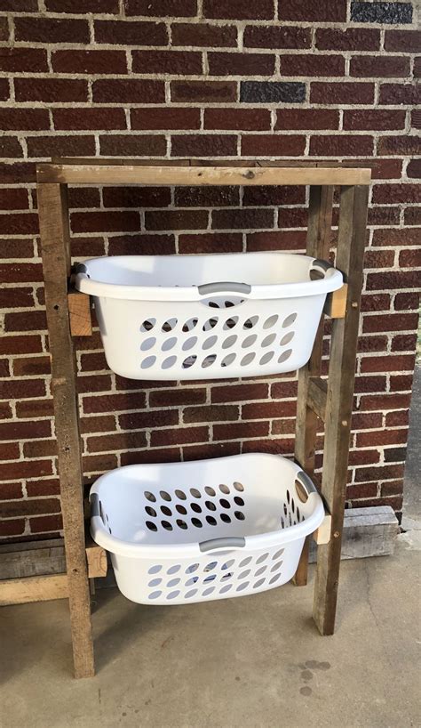 Two White Laundry Baskets Sitting On Top Of A Wooden Shelf Next To A