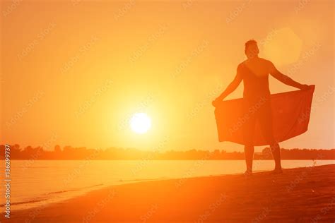 Silhouette Of A Naked Man With A Towel On The Beach At Sunset Stock