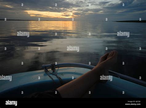 Tranquil Scene Of A Womans Legs Resting On The Side Of A Boat On The