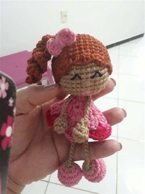 A Small Crocheted Doll Is Being Held In The Palm Of Someone S Hand