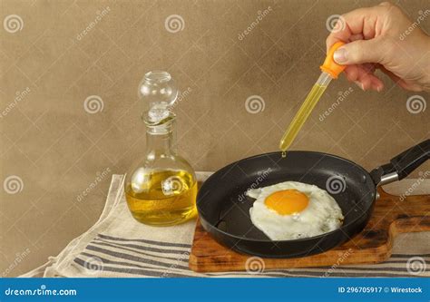 Woman Frying An Egg Pouring Olive Oil With An Dropper Stock Image