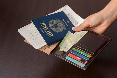 M O Segurando O Passaporte Brasileiro Sobre A Mesa Foto Premium