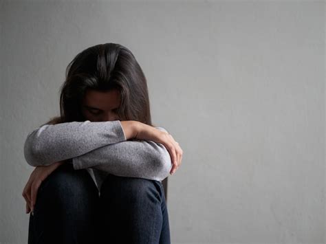 Mulher Deprimida Que Senta Se Em Uma Cadeira Na Sala Escura Em Casa