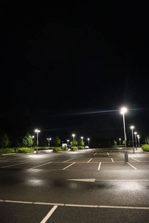 An Empty Parking Lot At Night With Street Lights