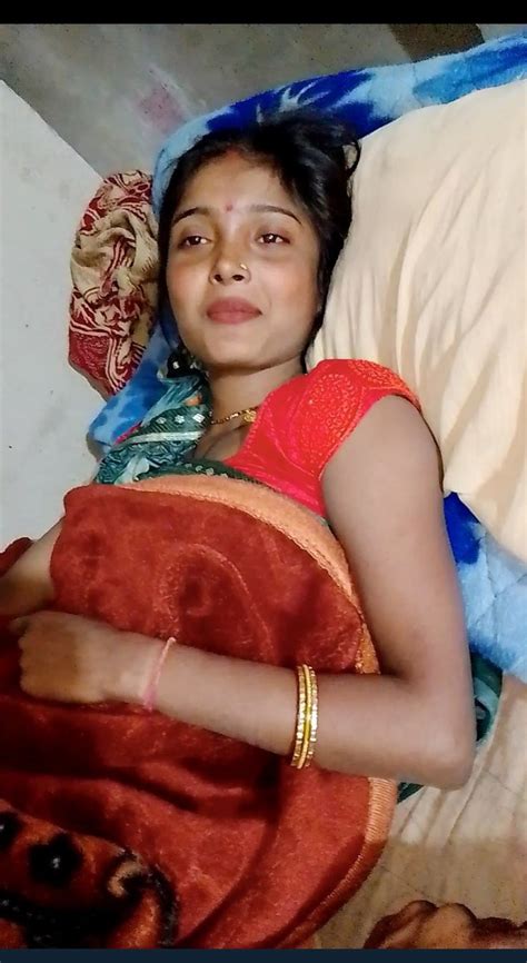 A Woman Laying In Bed With Her Arm Wrapped Around The Head And Wearing An Orange Sari