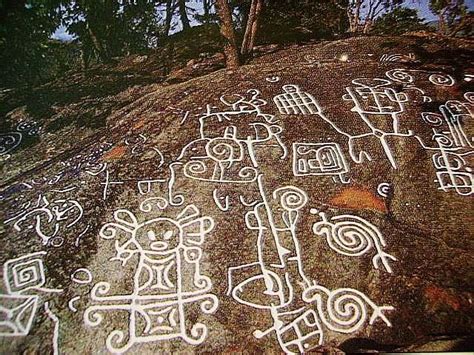 The Rock Has Some Drawings On It And Trees In The Backgroung Area