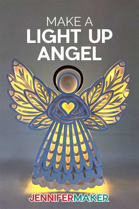 A Light Up Angel Sitting On Top Of A Table Next To A Sign That Says