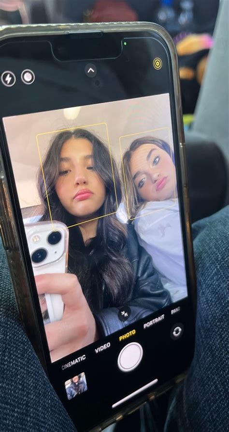 A Person Holding Up A Cell Phone With An Image Of Two Women On The Screen