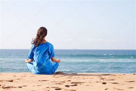 Meditación enfermera joven en la playa fotografía de stock