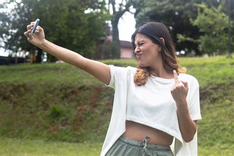 Premium Photo Latin Female Demonstrating The Fuck Off Gesture To The Camera While Taking A Selfie