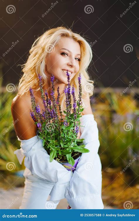 An Attractive Middle Aged Blonde Woman Topless In A White Shirt With