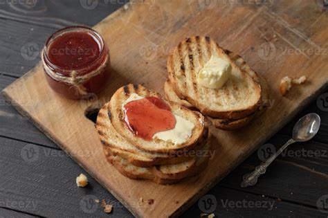 pan tostado con mermelada de fresa casera y sobre mesa rústica con