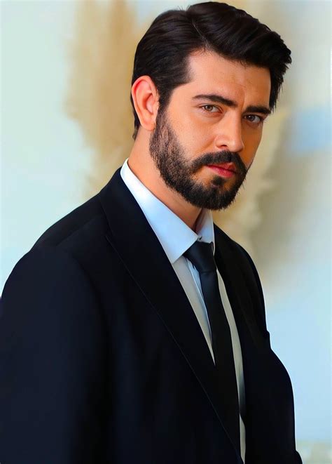 A Man With A Beard Wearing A Black Suit And White Shirt Is Looking At