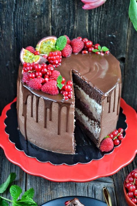 A Chocolate Cake With Raspberries Is On A Red Plate Next To A Piece Of Cake
