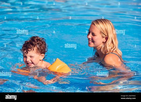 Mère et fils dans la piscine extérieure pendant les vacances d été