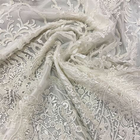 Tissu tulle brodé perlé arabesques paisley blanc cassé Tissus en Ligne