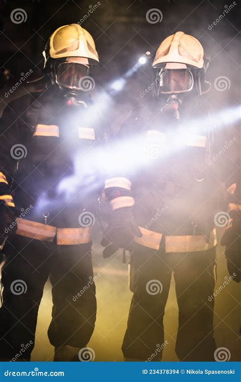 Firemen Wearing Uniform Standing Behind Fire Tape And Many Fire Engine