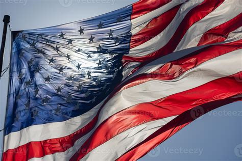 Backlit American Flag Waving In Wind Against A Deep Blue Sky 16446279