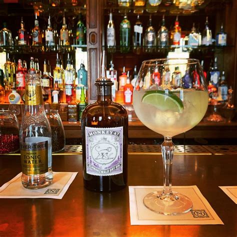 A Bottle Of Alcohol Sitting On Top Of A Bar Next To A Glass Filled With