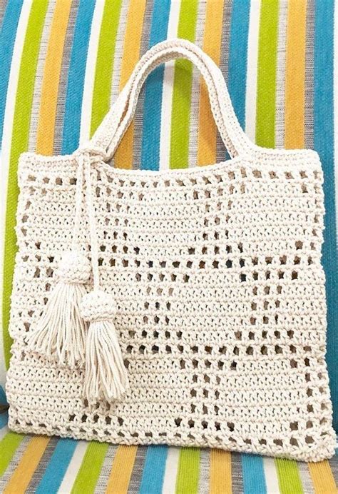 A White Crocheted Bag Sitting On Top Of A Striped Couch