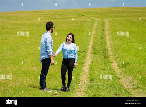 Two Persons Holding Hands In The Field Beautiful Couple Holding Hands Looking At Each Other In