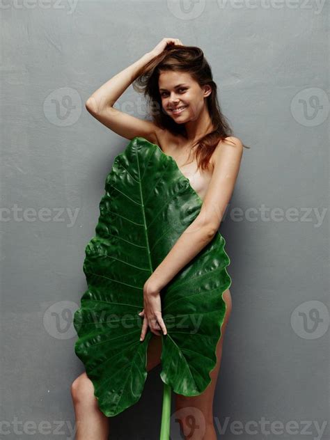 Smiling Woman With Naked Body Hiding Behind Large Green Leaf Isolated